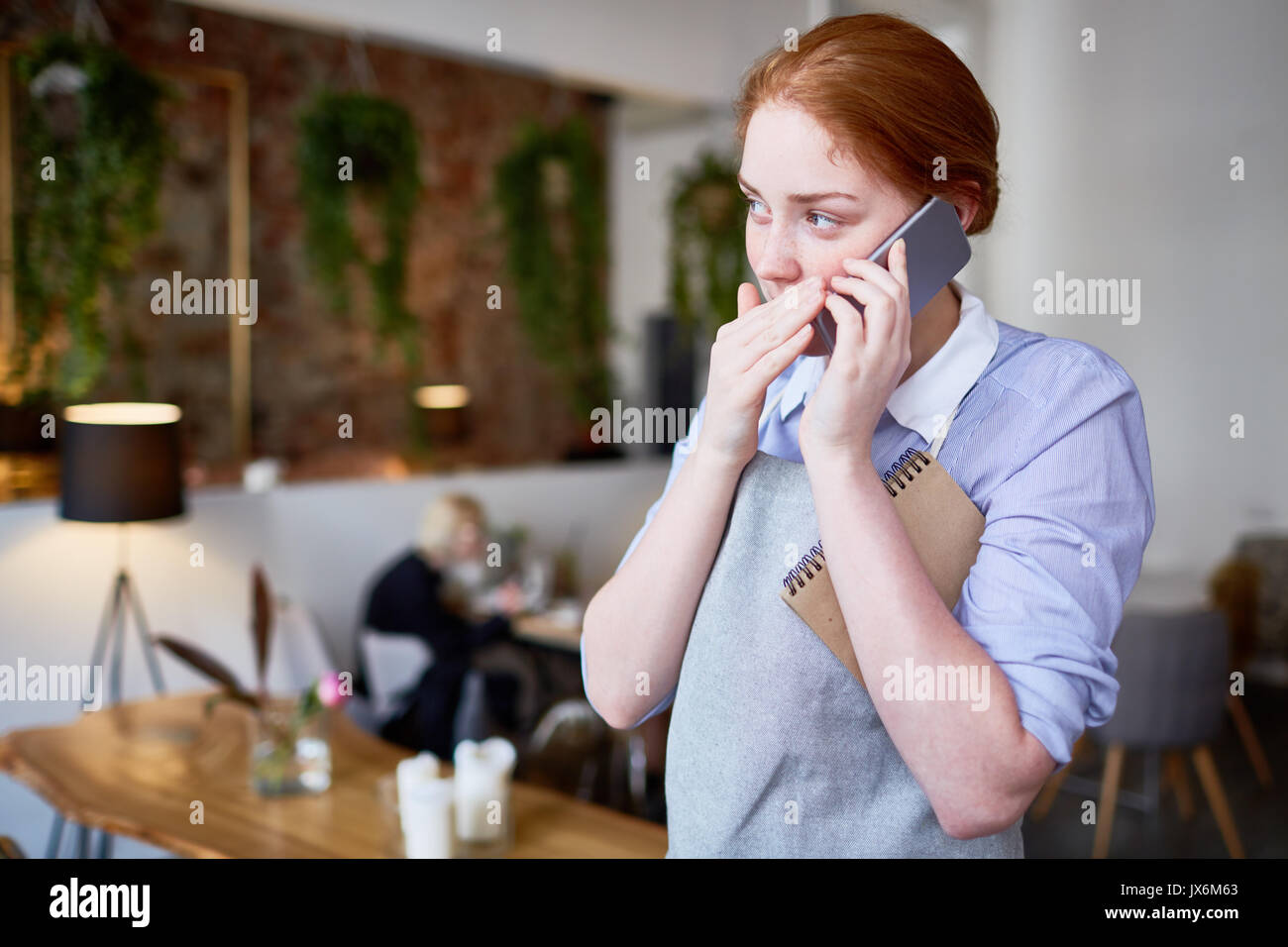 Pretty Waitress Using Smartphone Stock Photo - Alamy