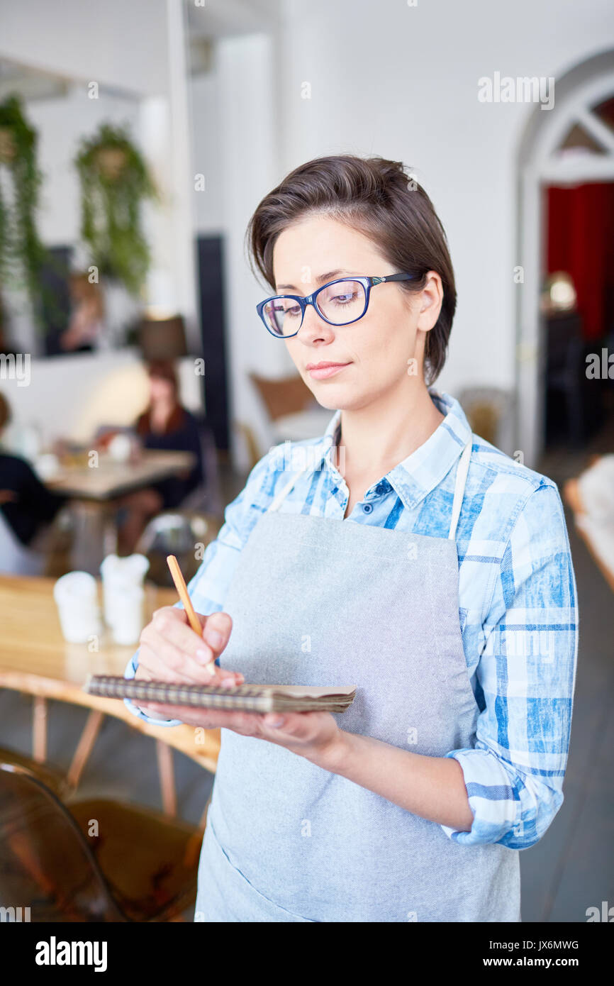 Pretty Waitress Wrapped up in Work Stock Photo - Alamy