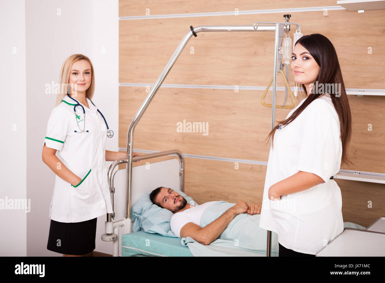 Patient in hospital room next to nurses Stock Photo - Alamy