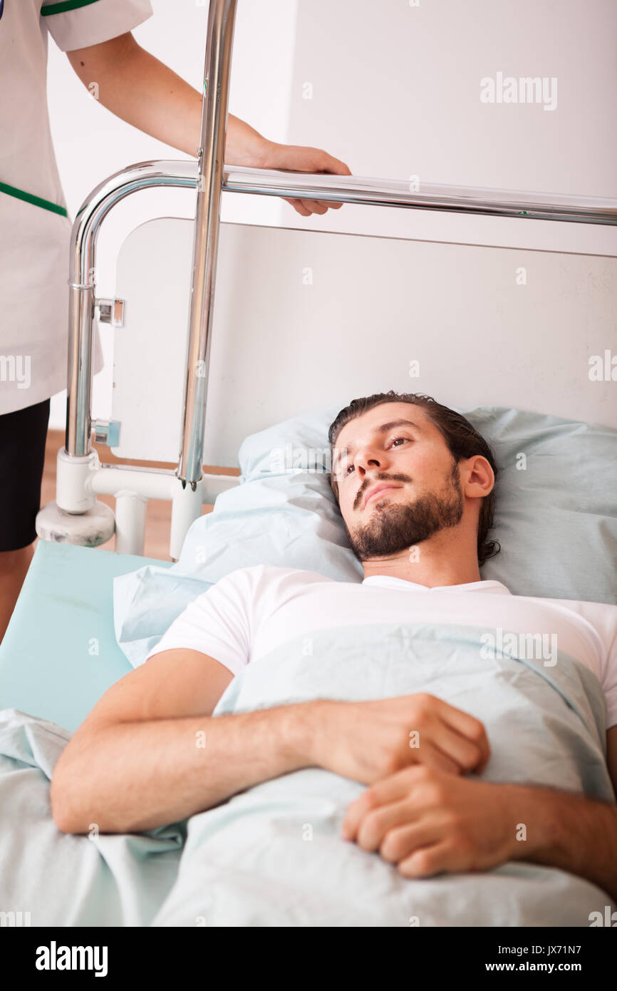 Sick Patient in hospital room next to nurses Stock Photo - Alamy