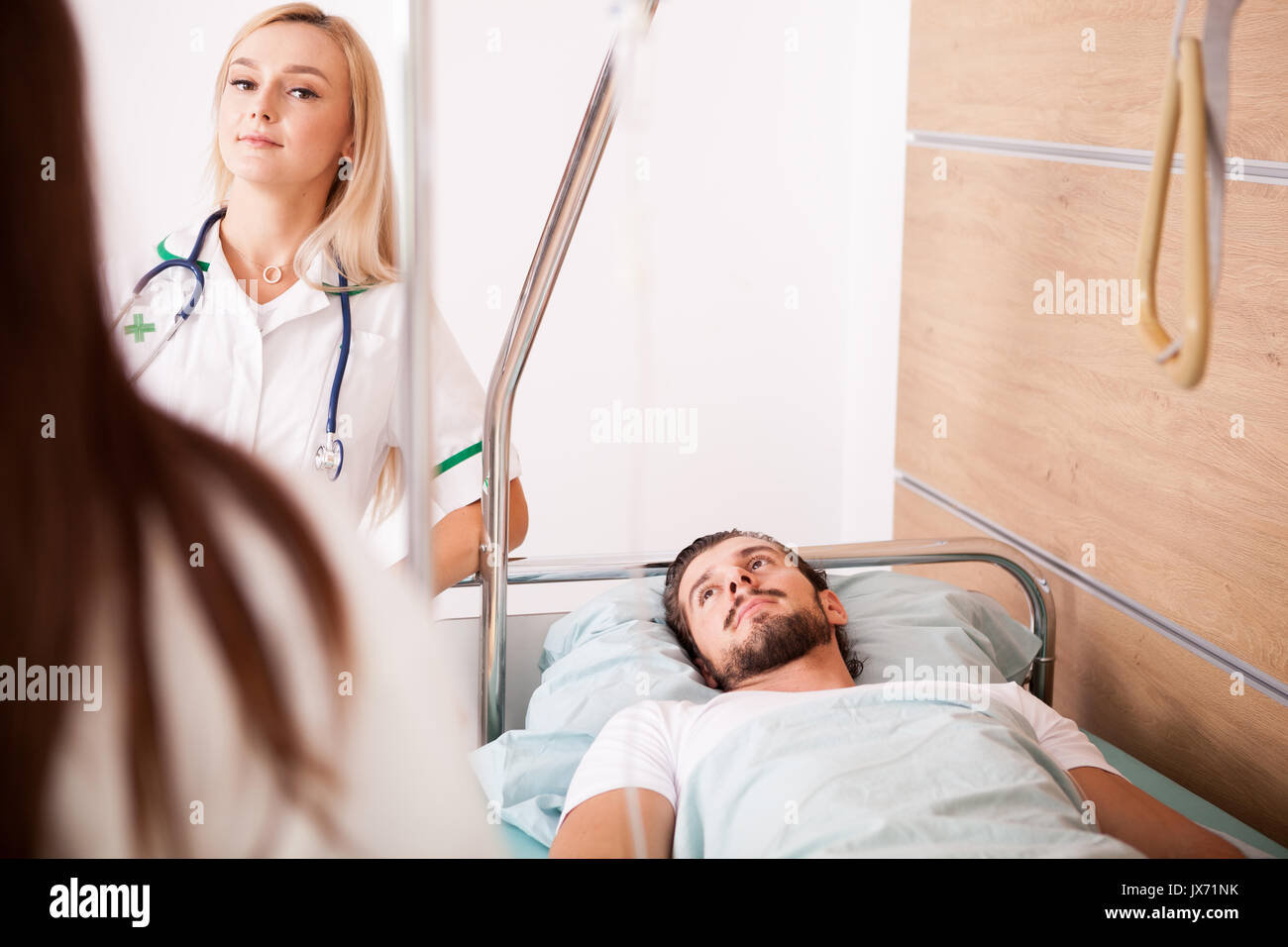 Sick male Patient in hospital room next to nurses Stock Photo - Alamy