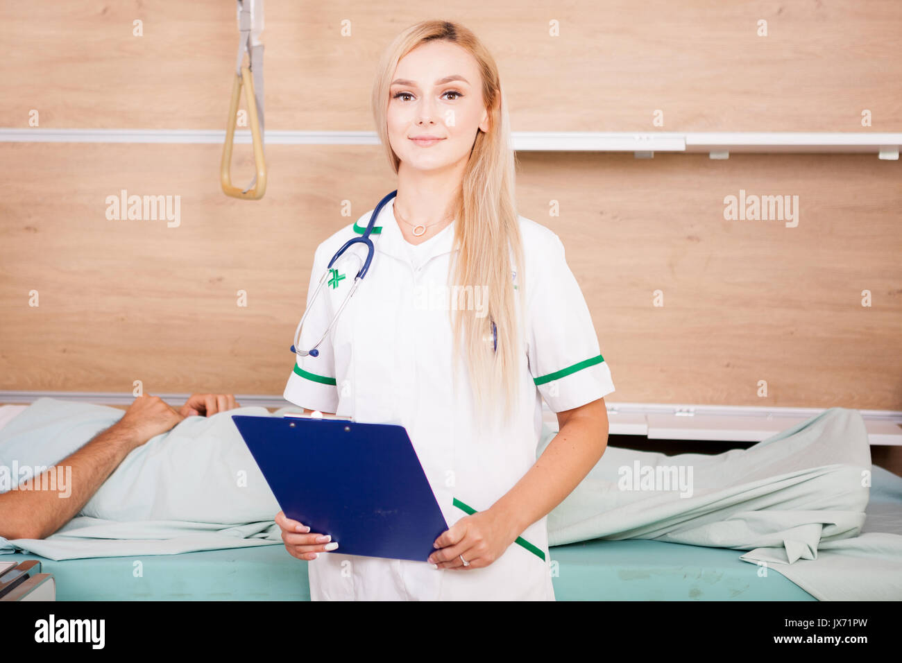 Patient in hospital room next to two nurses Stock Photo - Alamy
