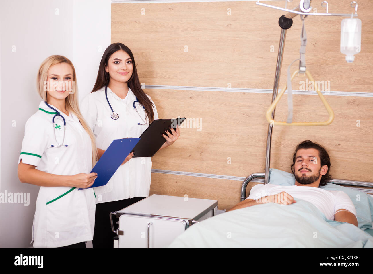 Patient in hospital room next to nurses Stock Photo - Alamy