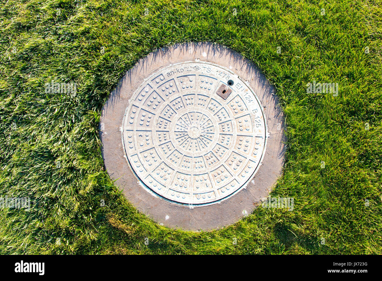 Metal manhole in a background of green grass on the field Stock Photo ...