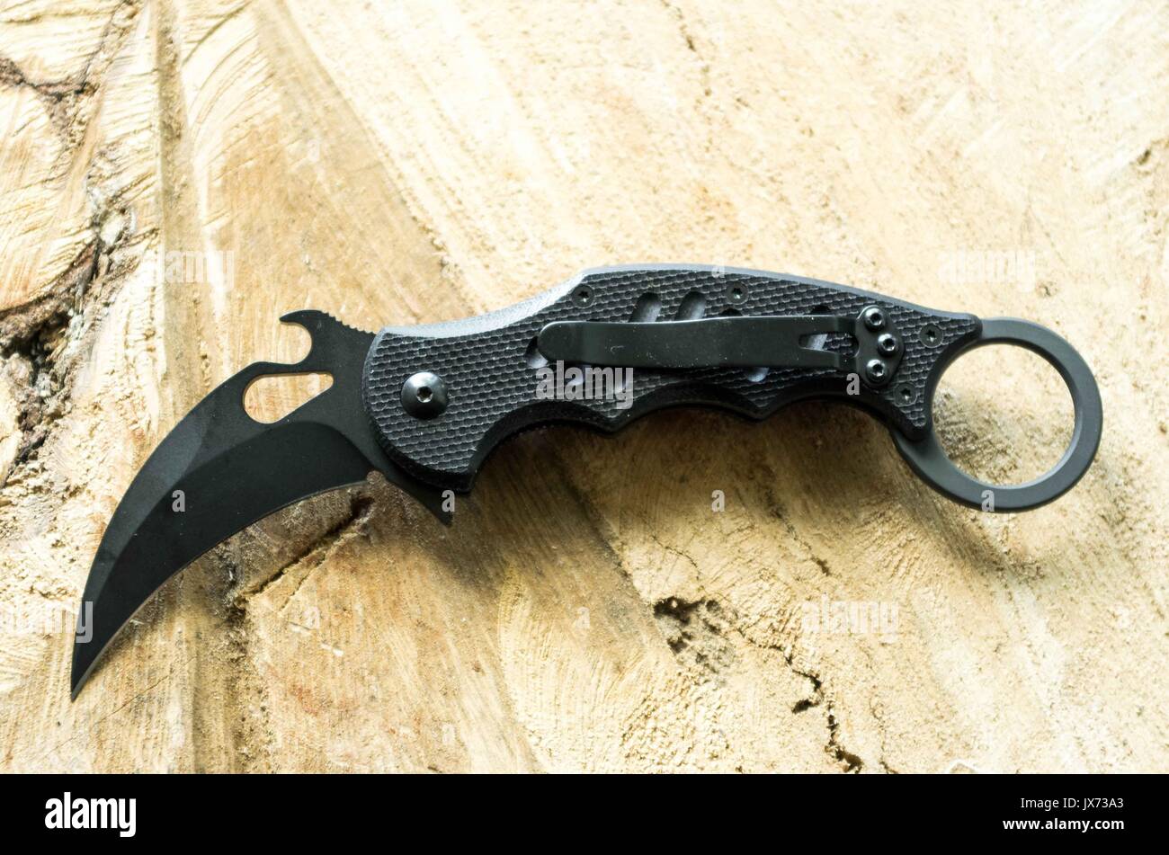 Black knife in the form of a claws predator oak stump. Military Stock ...