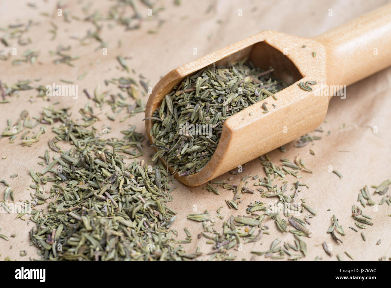 dried thyme leaves in measuring spoon on paper background Stock Photo ...