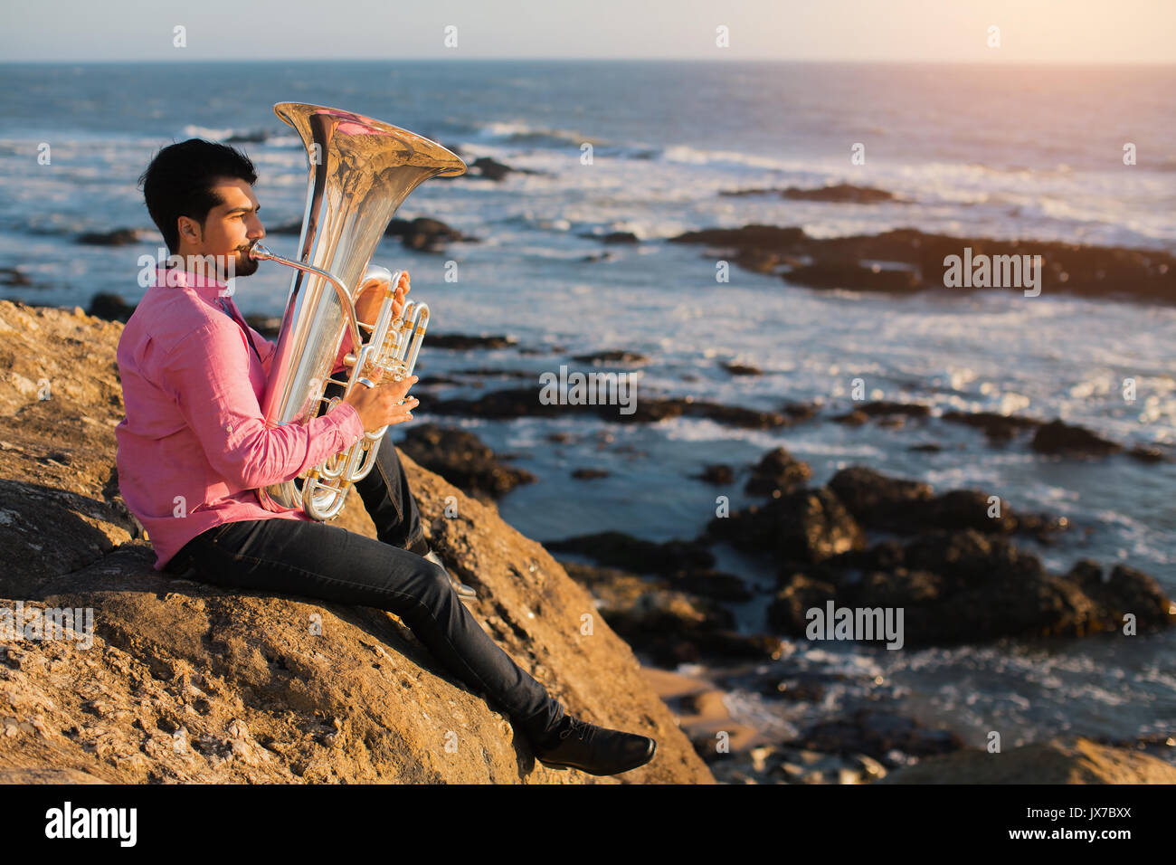 Musician play to musical instrument Tuba on romantic sea shore Stock ...