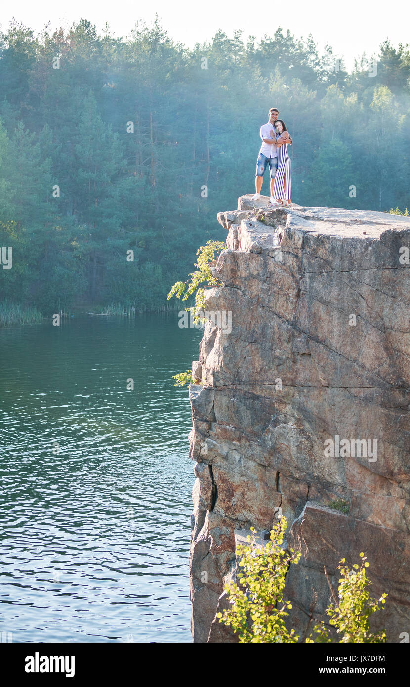 Romantic young couple standing on cliff over river Stock Photo - Alamy