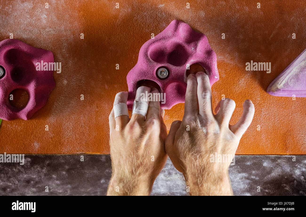 Closeup of rock climber's hands gripping handhold in indoor climbing ...
