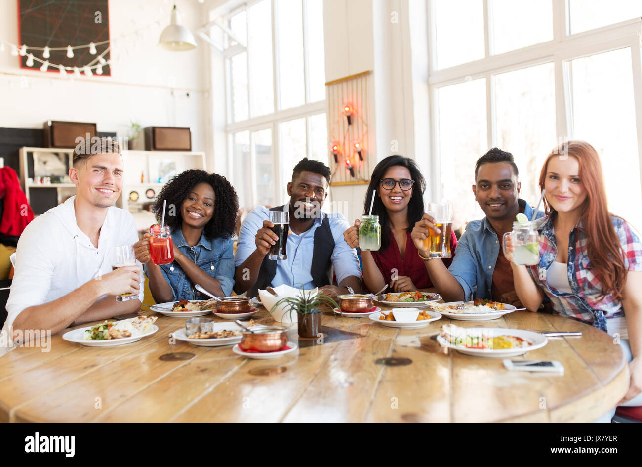 happy friends eating and drinking at restaurant Stock Photo - Alamy