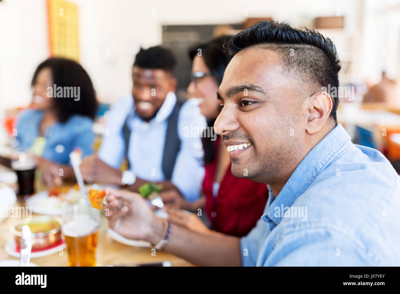 happy friends eating and talking at restaurant Stock Photo - Alamy