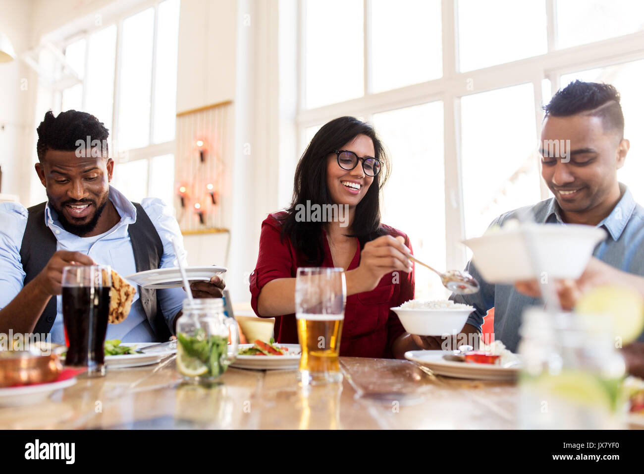 happy friends eating at restaurant Stock Photo - Alamy