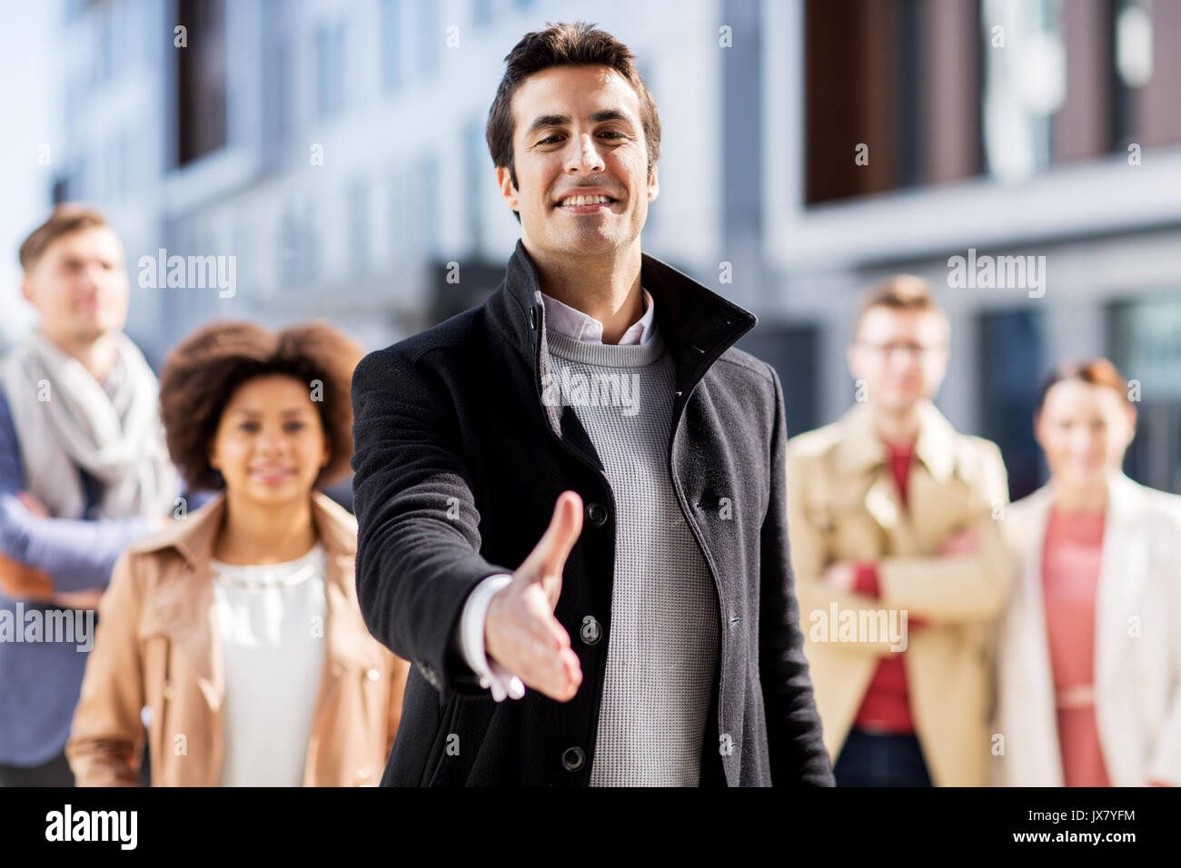 man giving hand for handshake on city street Stock Photo - Alamy