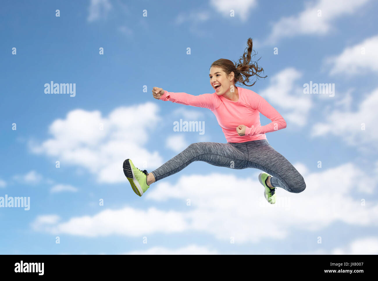 happy sporty young woman jumping in fighting pose Stock Photo - Alamy