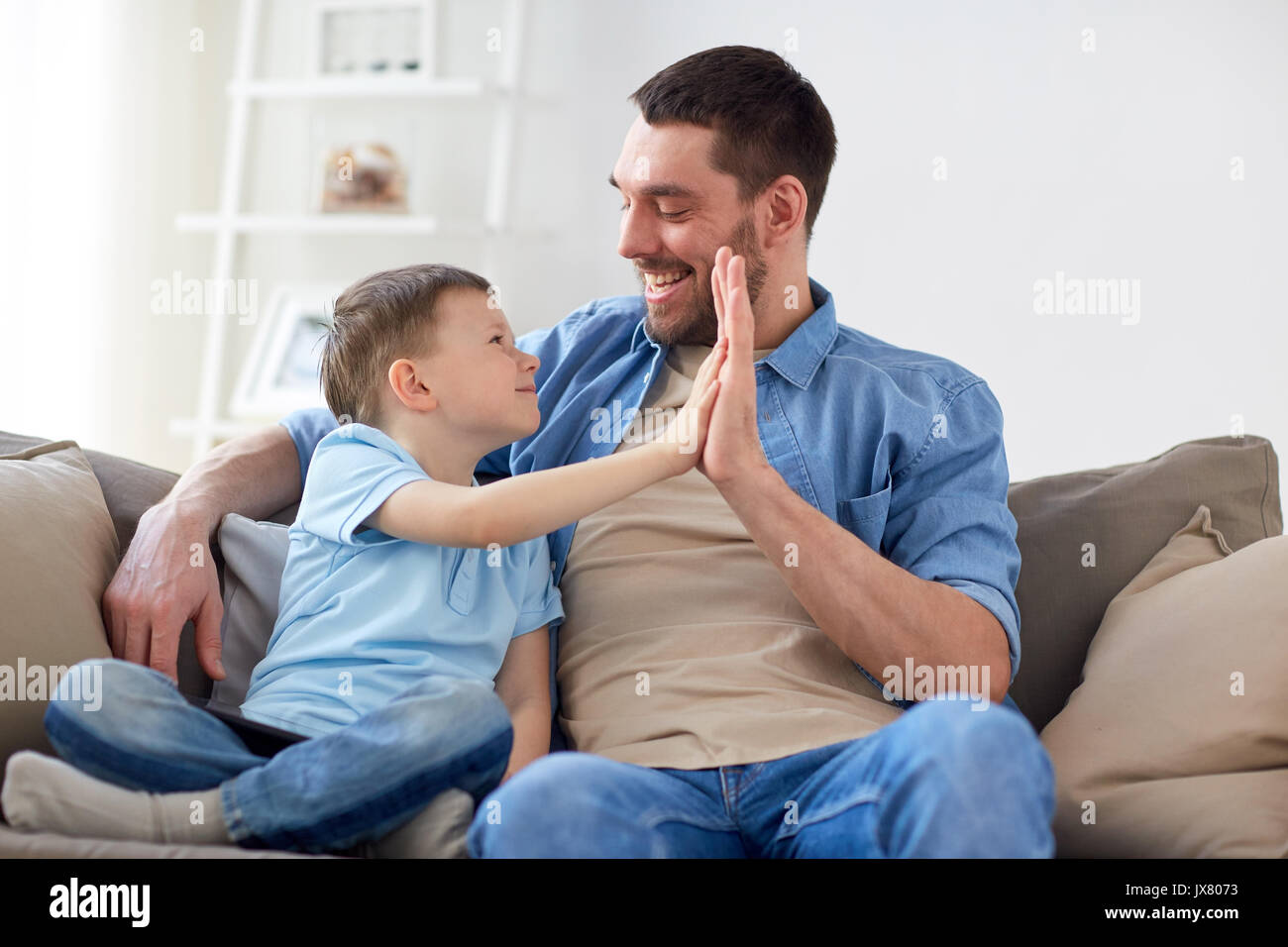 father and son doing high five at home Stock Photo - Alamy