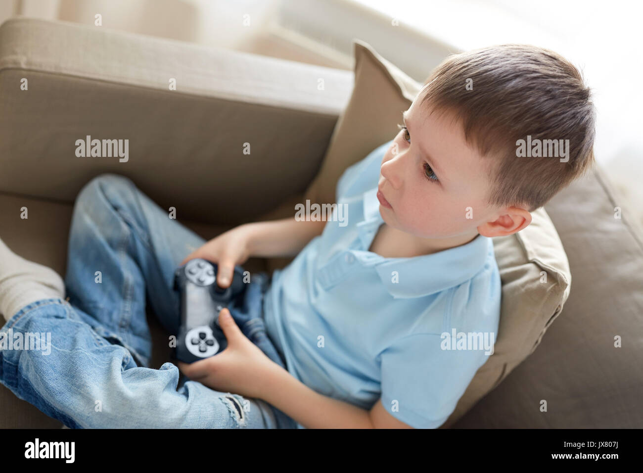 little boy with gamepad playing video game at home Stock Photo - Alamy