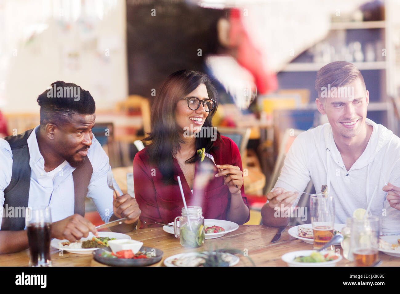 happy friends eating at restaurant Stock Photo - Alamy