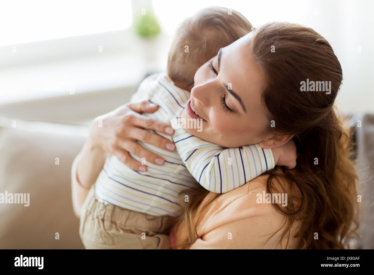 happy young mother hugging little baby at home Stock Photo - Alamy