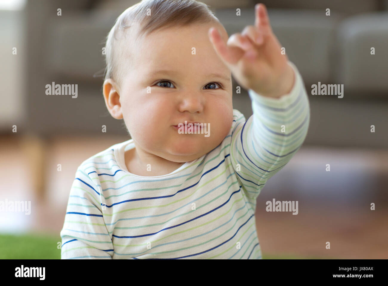 baby boy showing rock hand sign at home Stock Photo - Alamy