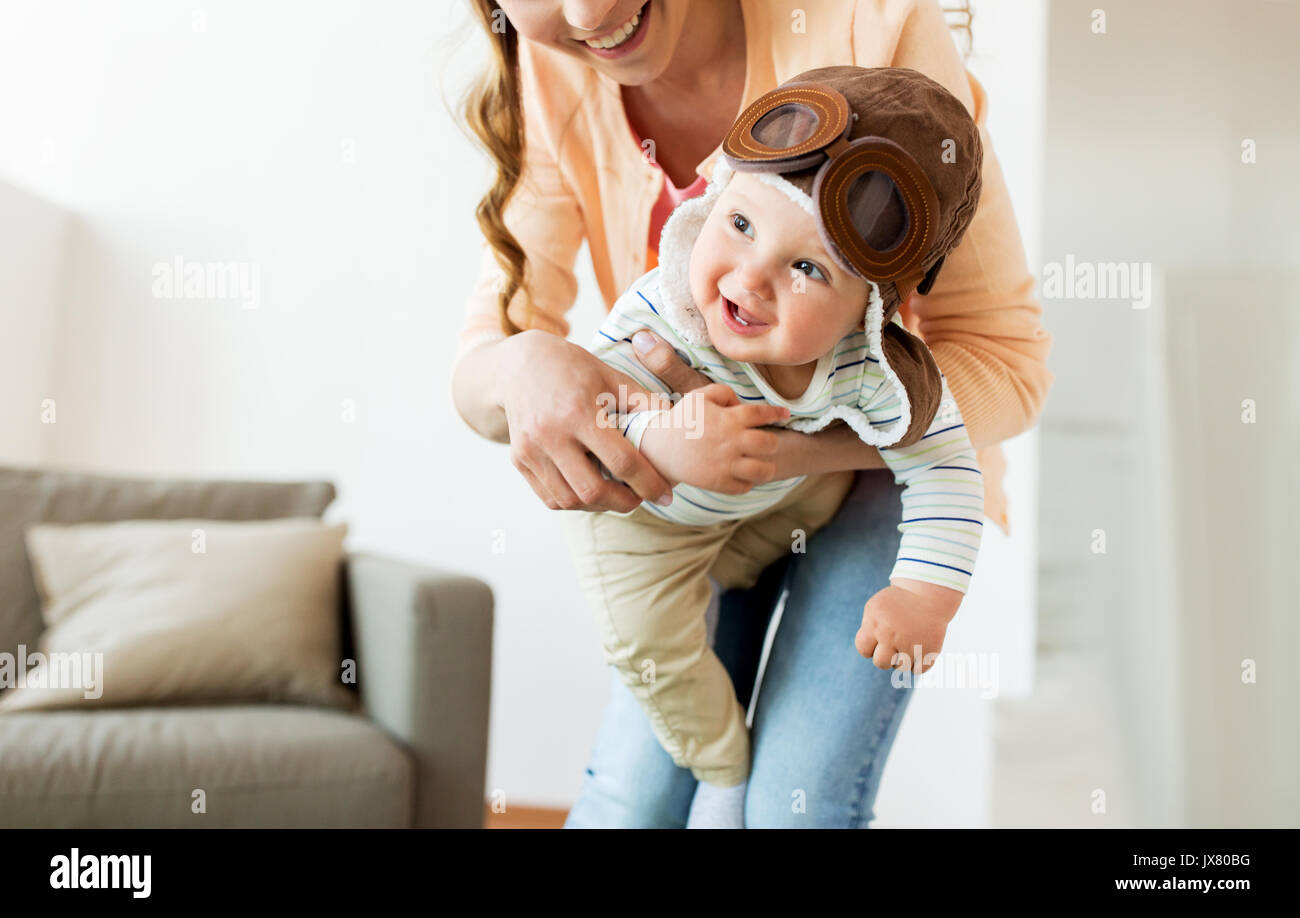 happy mother with baby wearing pilot hat at home Stock Photo - Alamy