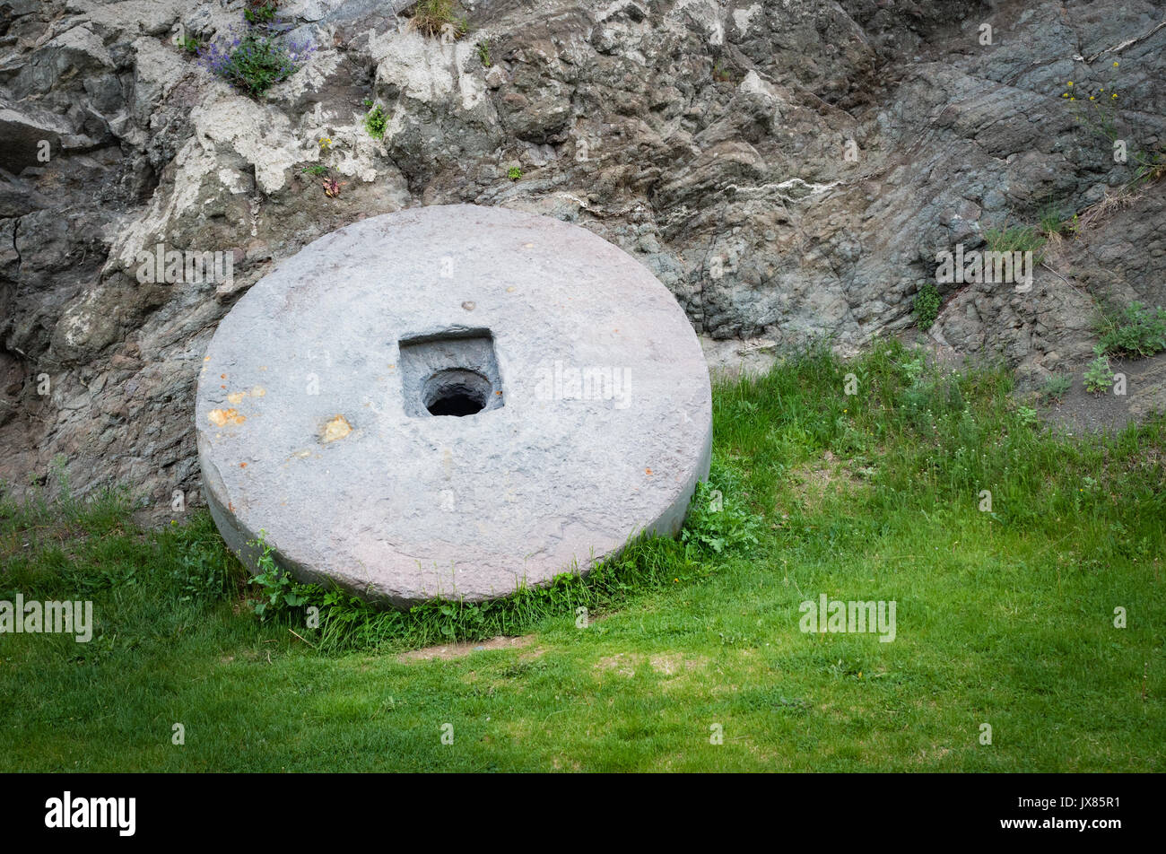 Stone granite wheel with rusted metal rim isolated on green grass Stock ...