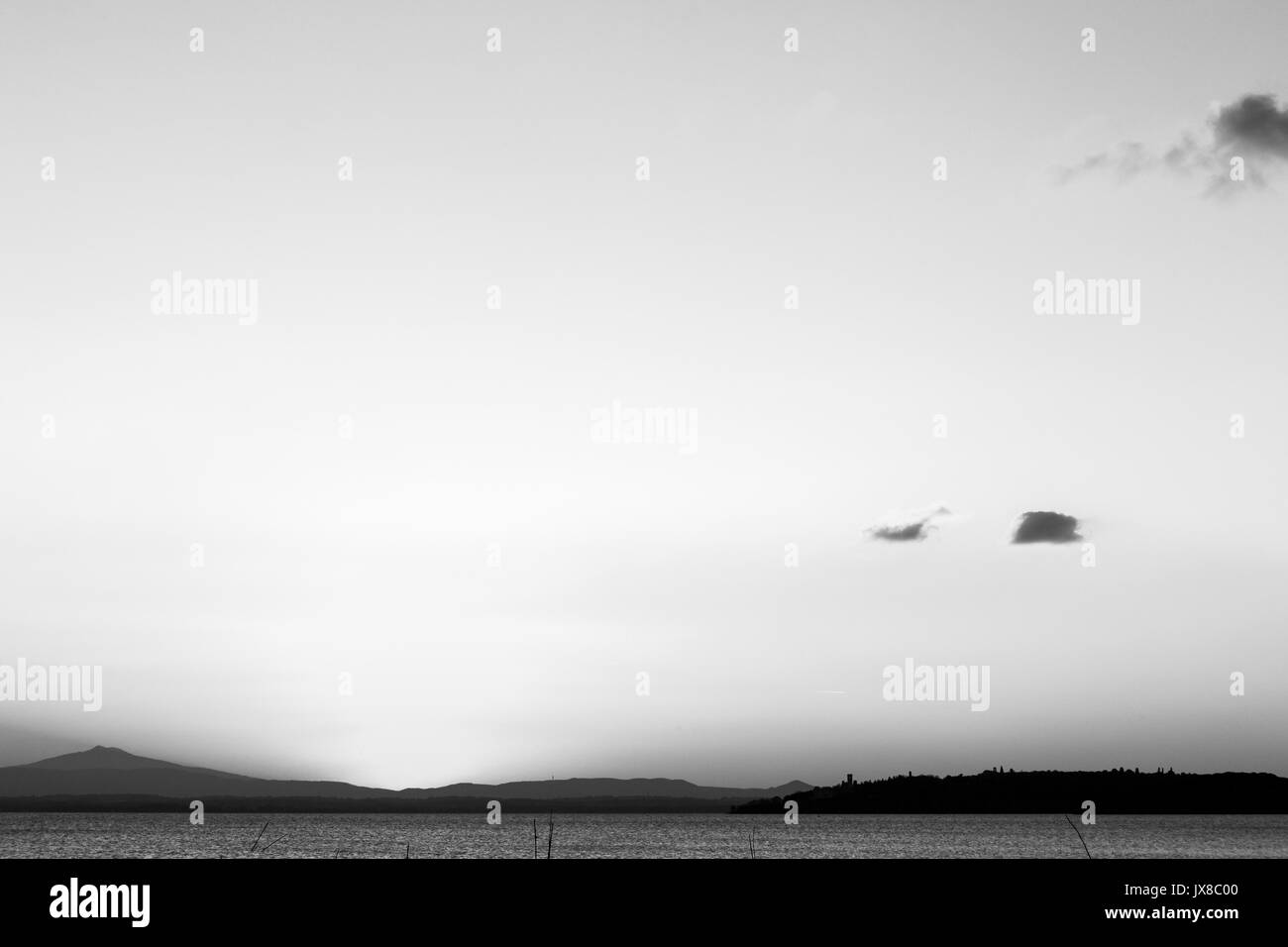 The end of sunset and the beginning of dusk on a lake, with big, epmpty ...