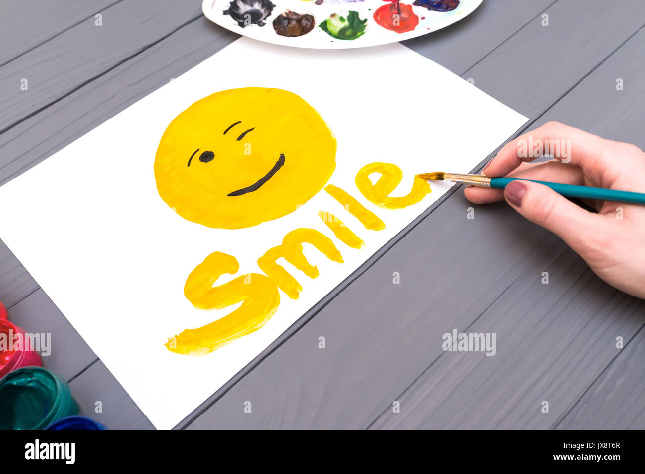 Hand draws smile on sheet Stock Photo - Alamy