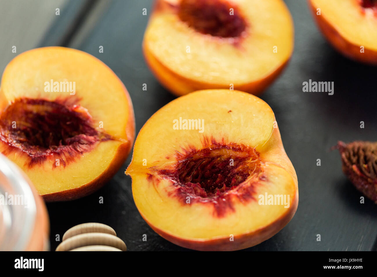 Cutting peaches in half for making grilled peaches Stock Photo - Alamy
