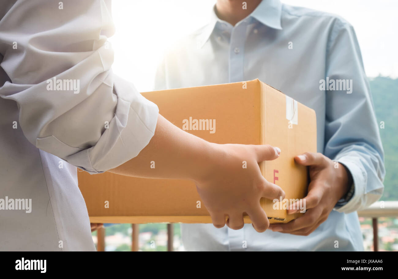 Close up hand of asia woman are receive a box from delivery man with ...