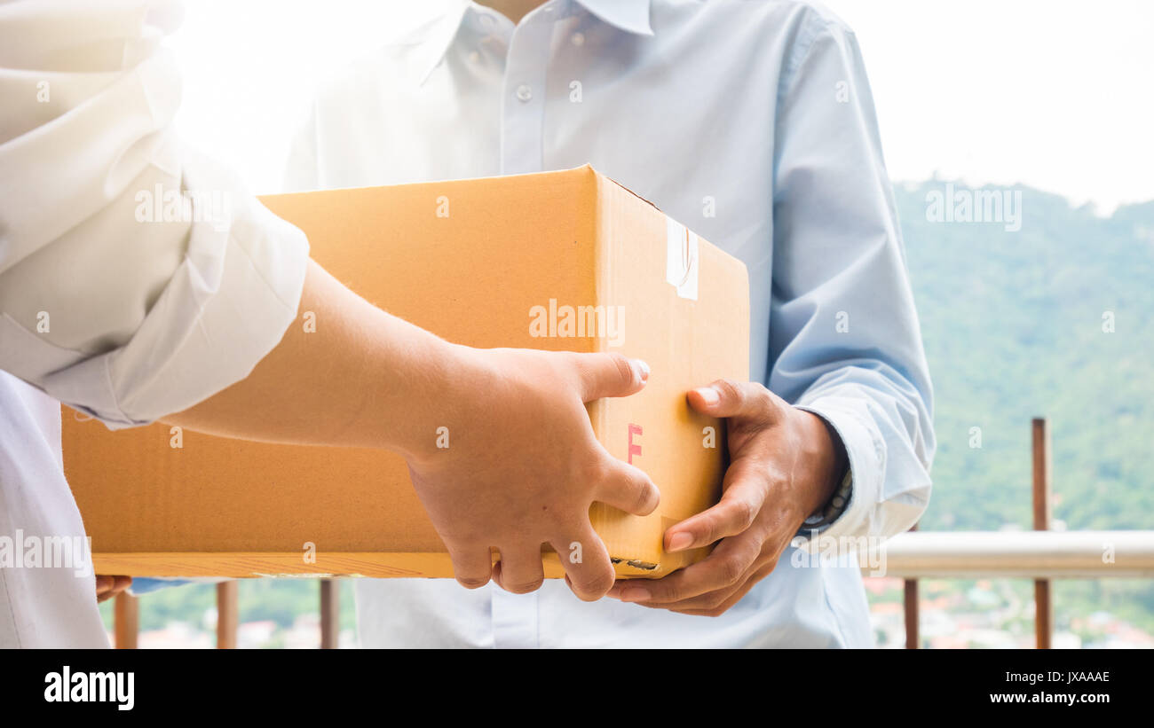 Close up hand of asia woman are receive a box from delivery man with ...