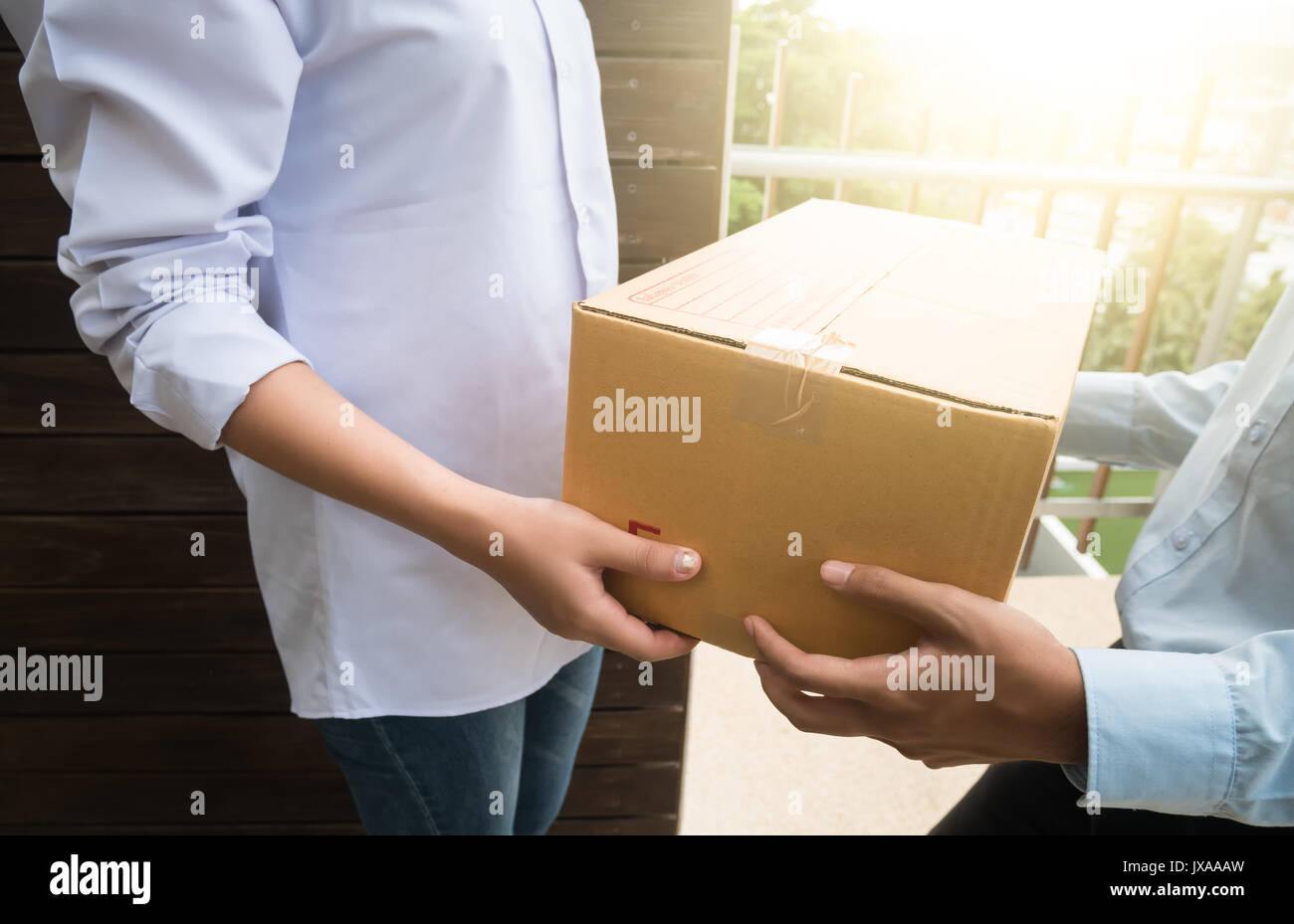 Close up hand of asia woman are receive a box from delivery man with ...