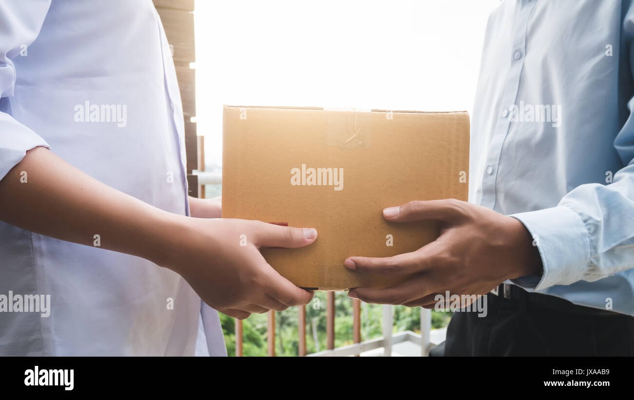 Close up hand of asia woman are receive a box from delivery man with ...