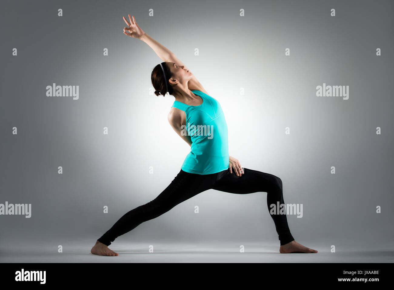 beautiful yoga lady using lunge posing standing in grey background and ...