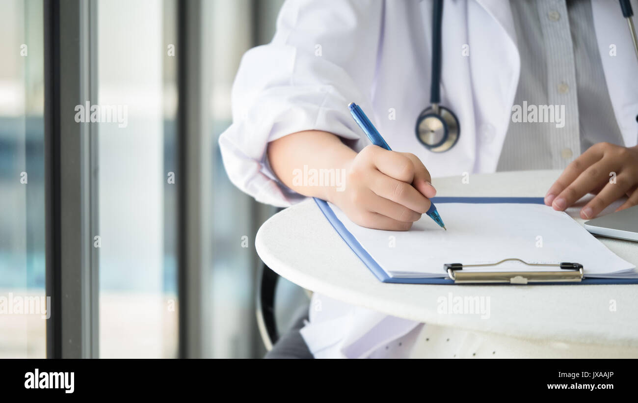 Hand of doctor holding pen are writing a report after treatment ...
