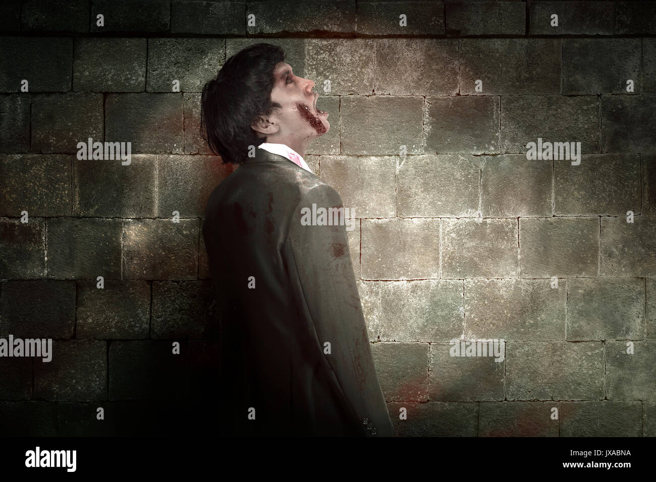 Scary asian zombie man with wounded face against black wall background ...