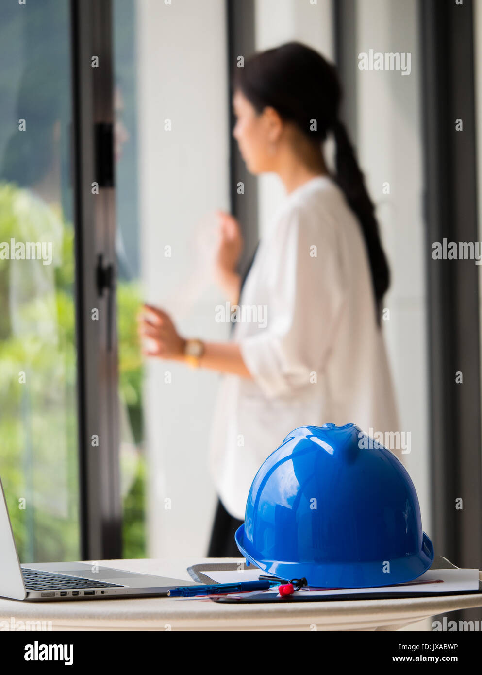 Engineer hats, laptops and a tool used in the design on the table with ...