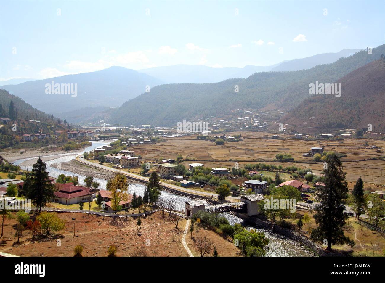 Bridge across the river with traditional Bhutanese style houses at Paro ...