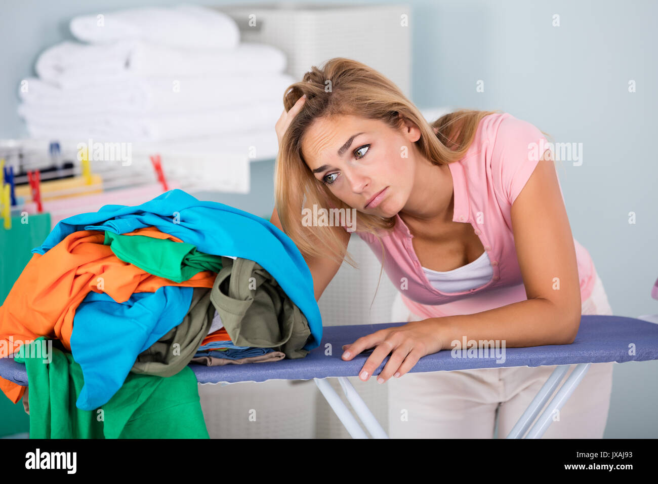 Young Unhappy Stressed Woman Looking At Pile Of Colorful Clothes On ...