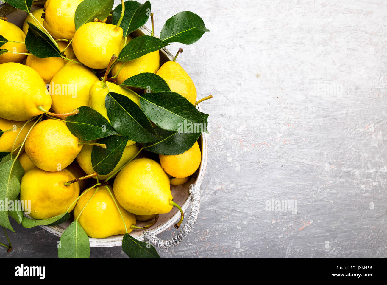 Yellow pear in grey basket in grey background. Harvest. Top view. Full ...