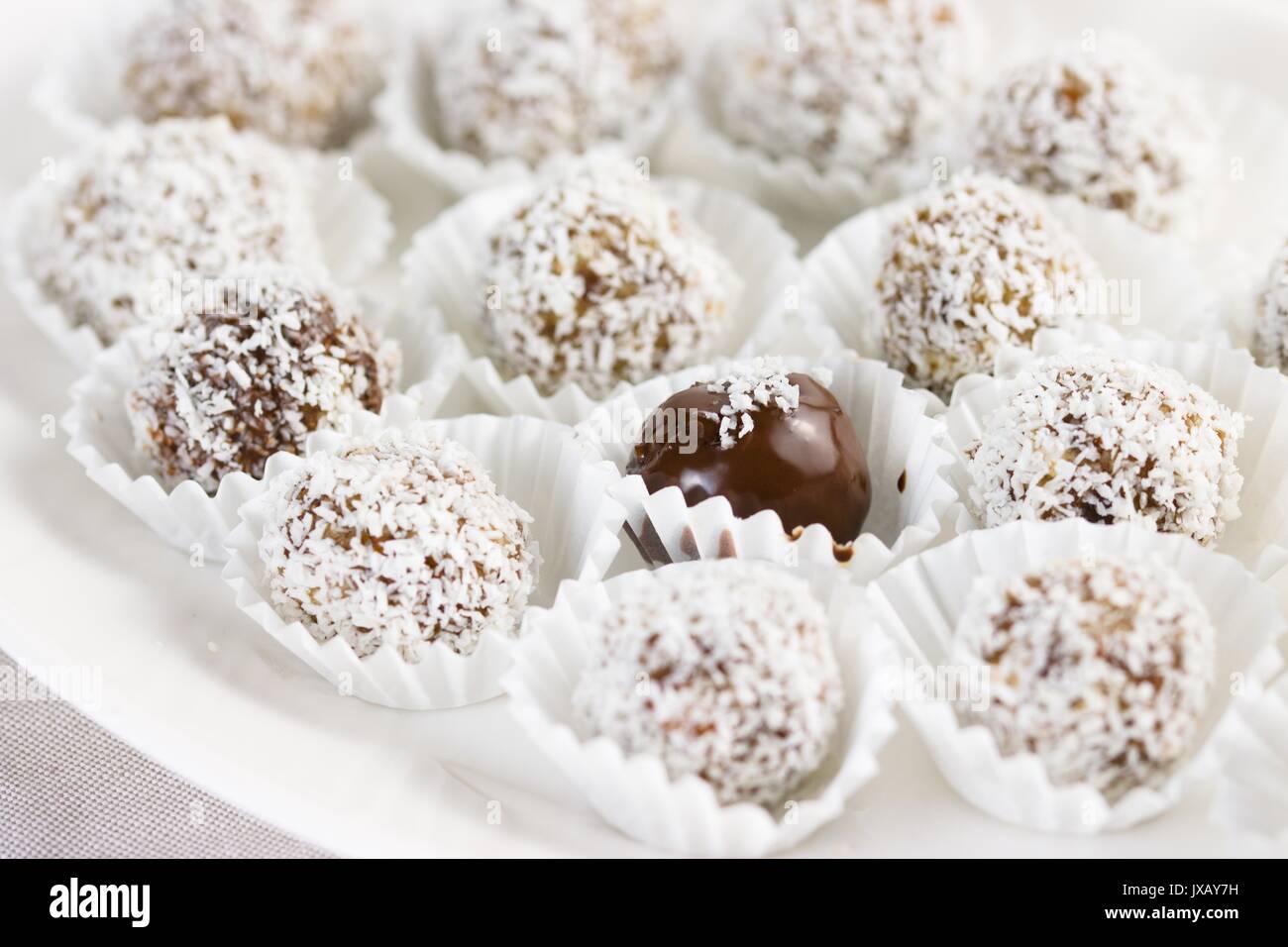 Date and almond pralines in ground coconut and one covered in chocolate ...
