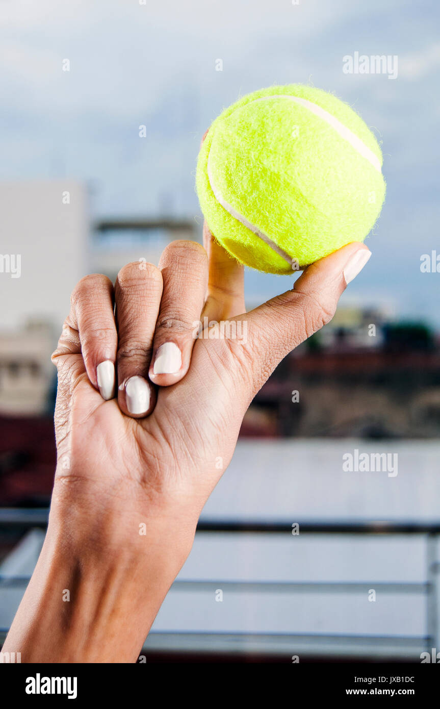 Woman's hand holding tennis ball Stock Photo - Alamy
