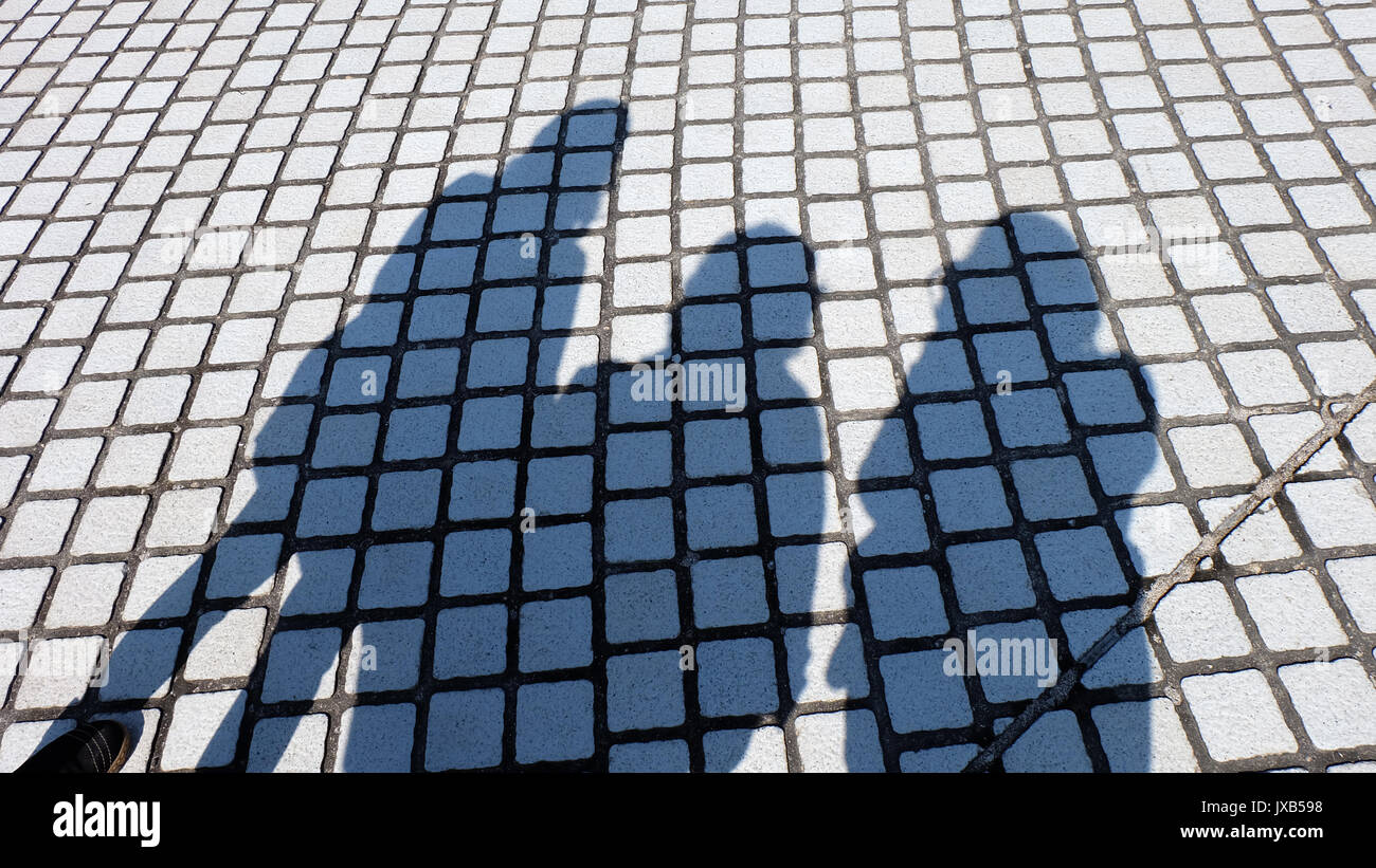 Shadow of three people on a tiled floor Stock Photo - Alamy