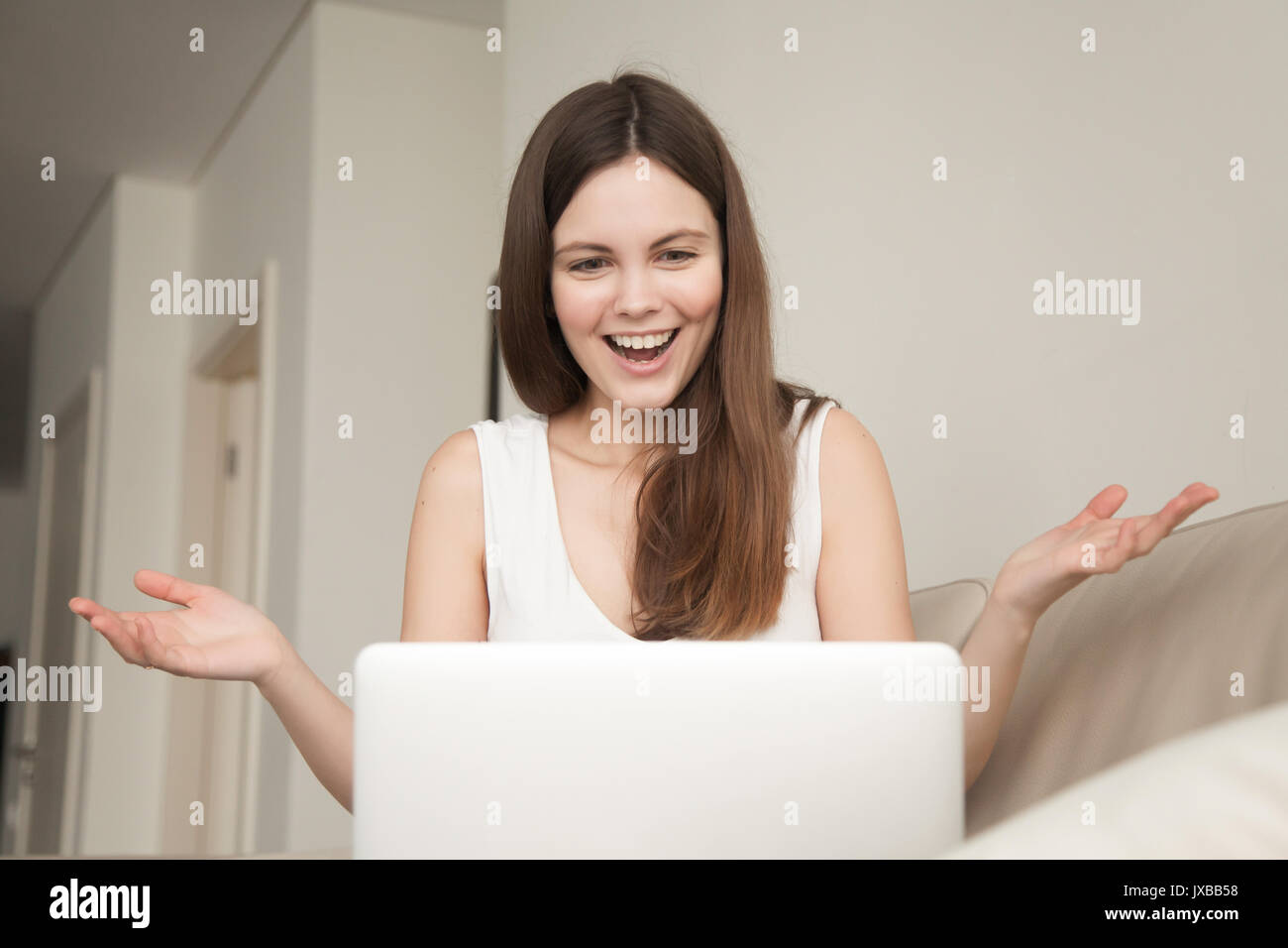 Excited woman surprisingly looking at laptop amazed by good news Stock ...