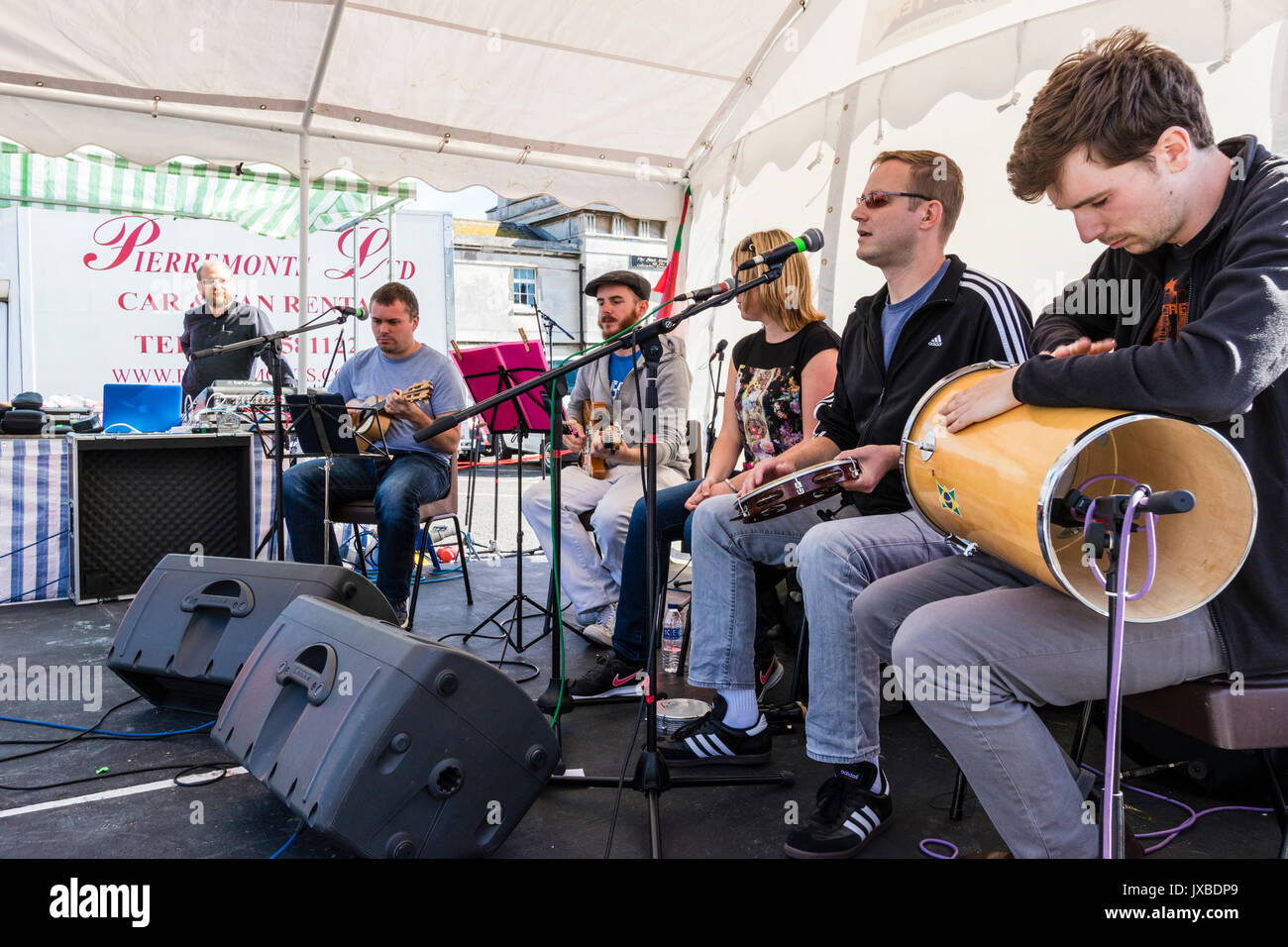 Five person music group Samba Azul sitting on small stage performing ...