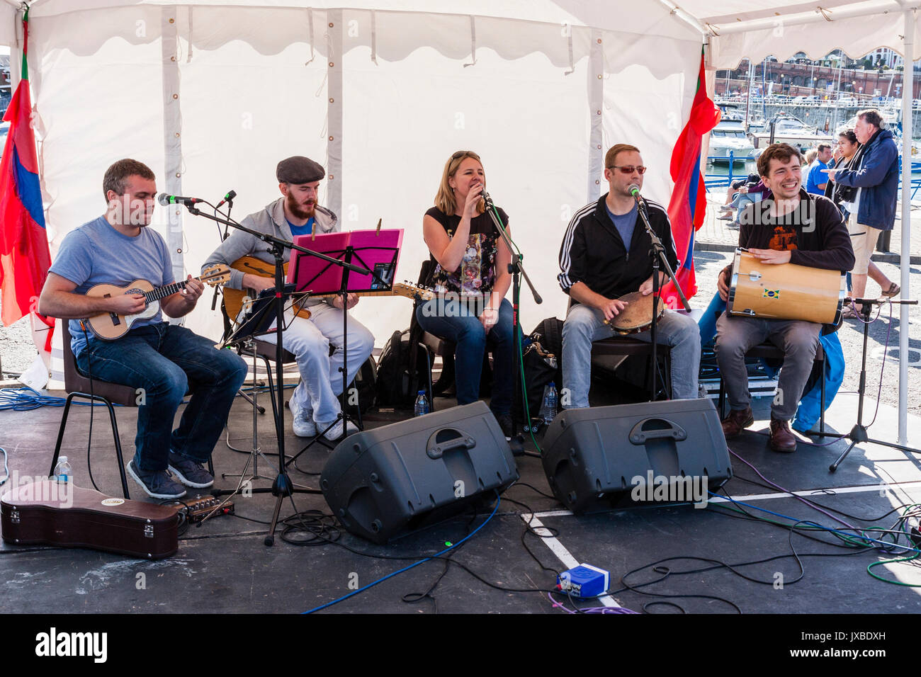 Five person music group Samba Azul sitting on small stage performing ...