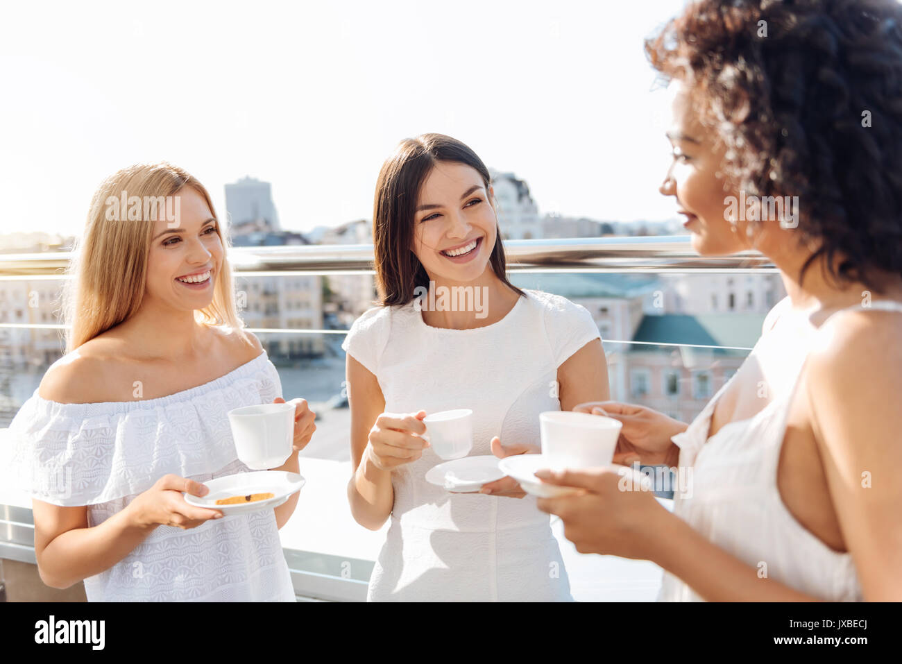 Cheerful attractive women having tea together Stock Photo - Alamy