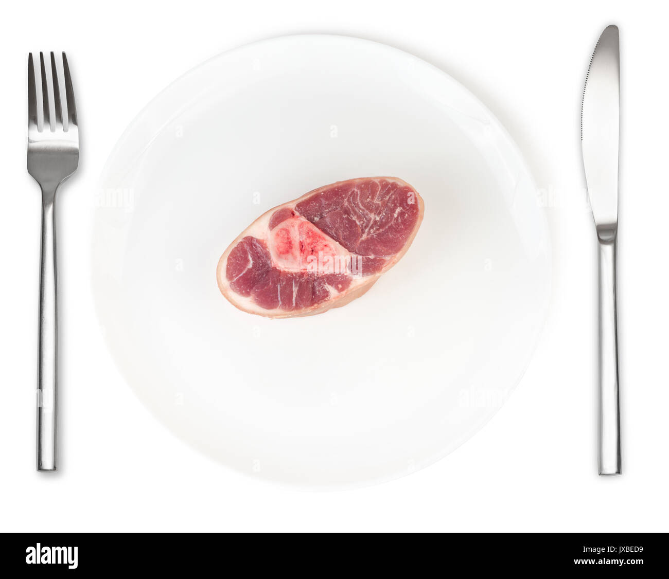 Eating Meat. Raw pork knuckle on plate with fork and knife isolated on ...