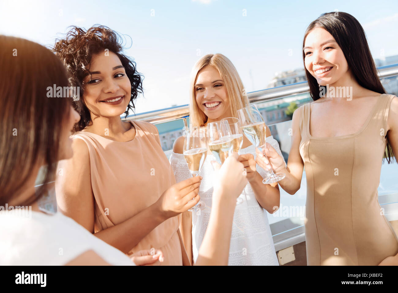 Positive pretty women drinking sparkling wine Stock Photo - Alamy