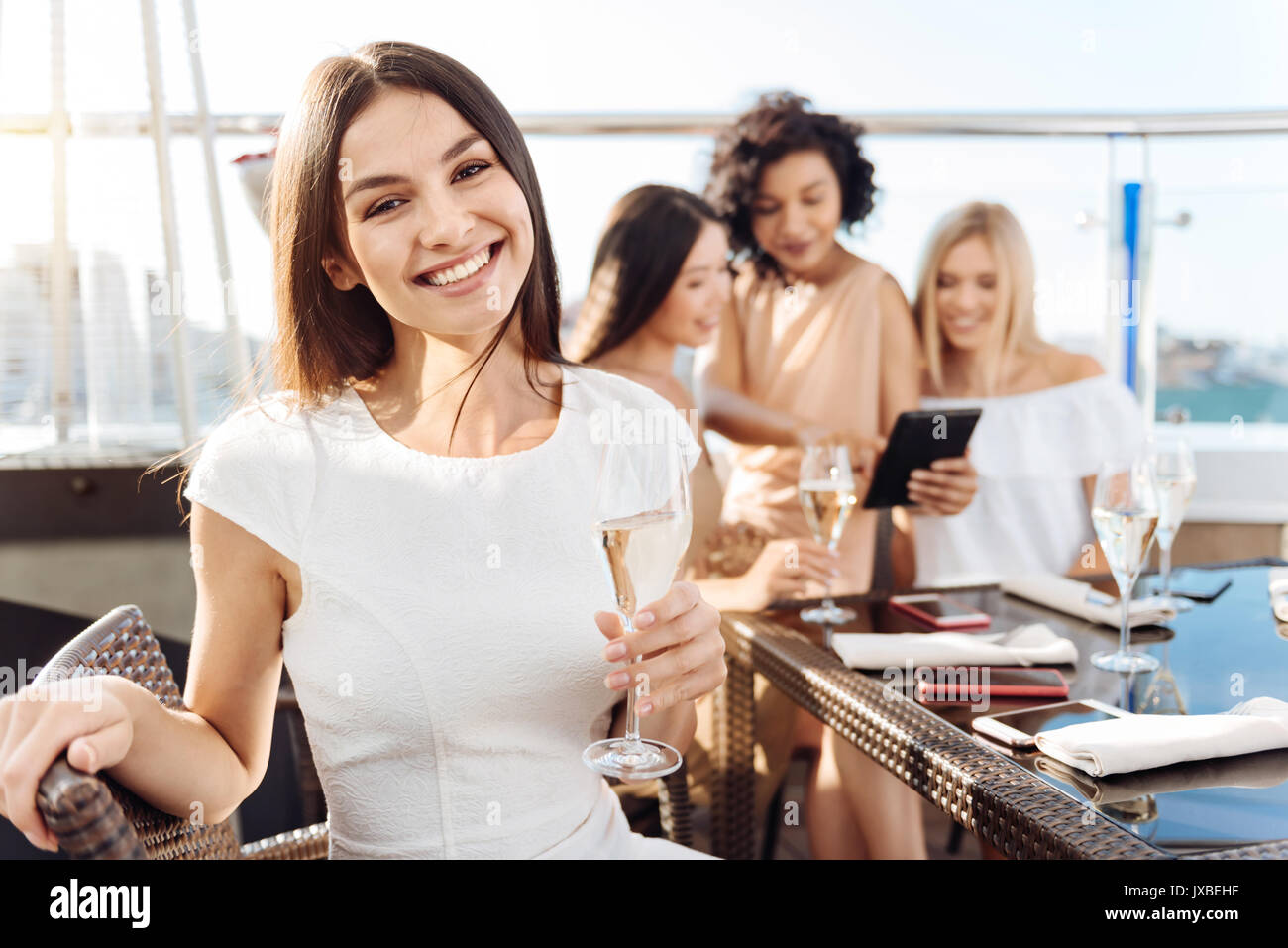 Happy elated woman holding a glass with champagne Stock Photo - Alamy