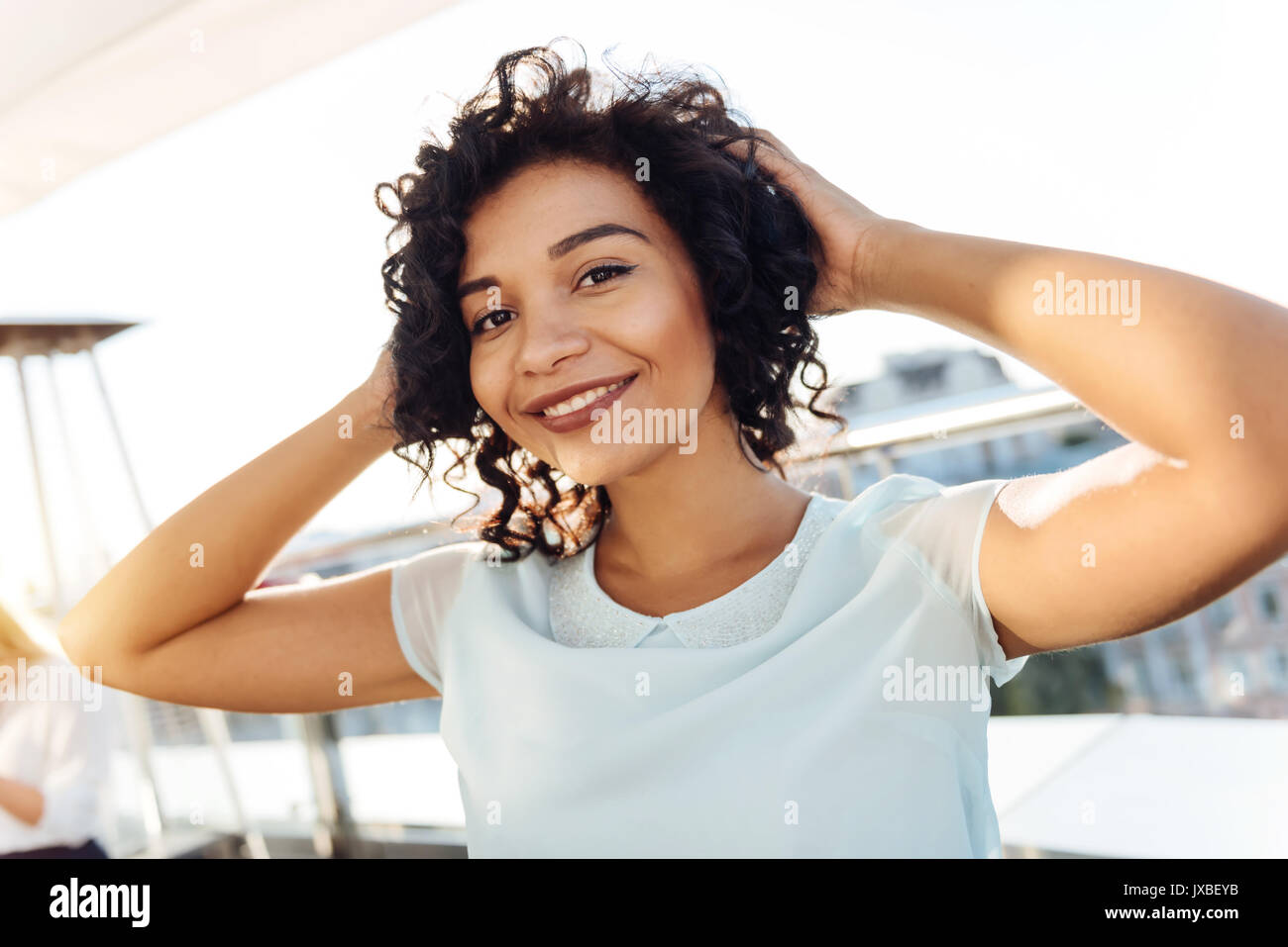 Positive delighted woman holding her hair Stock Photo - Alamy